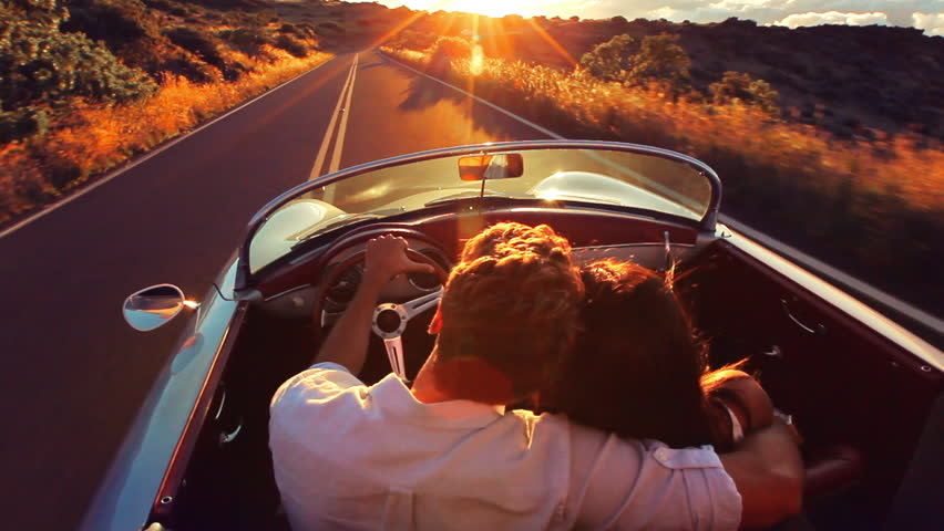 Happy Couple Driving On Country Road Into The Sunset In Classic Vintage ...