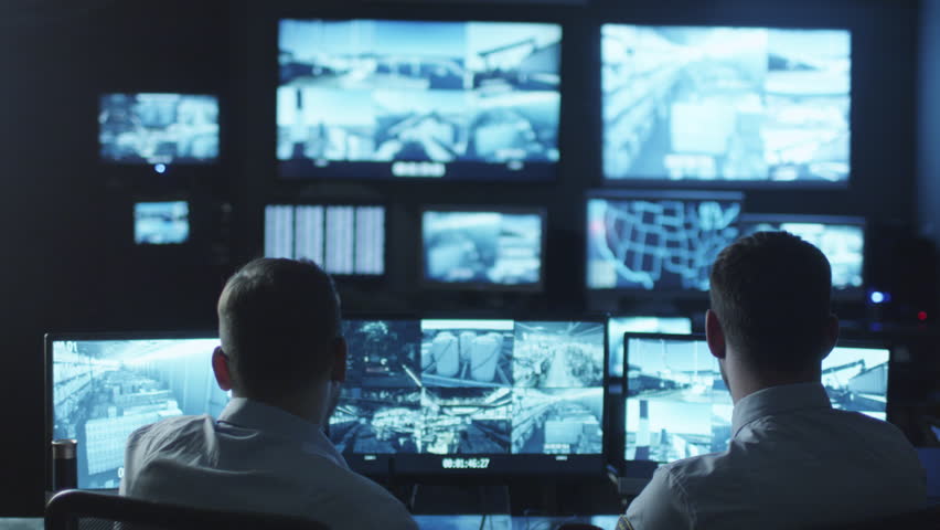 In The Security Command Center Officer At His Workstation Monitors ...
