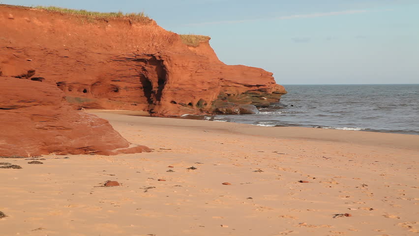 Waves Rolling In On An Empty Beach With Red Sandstone Cliffs On Prince ...