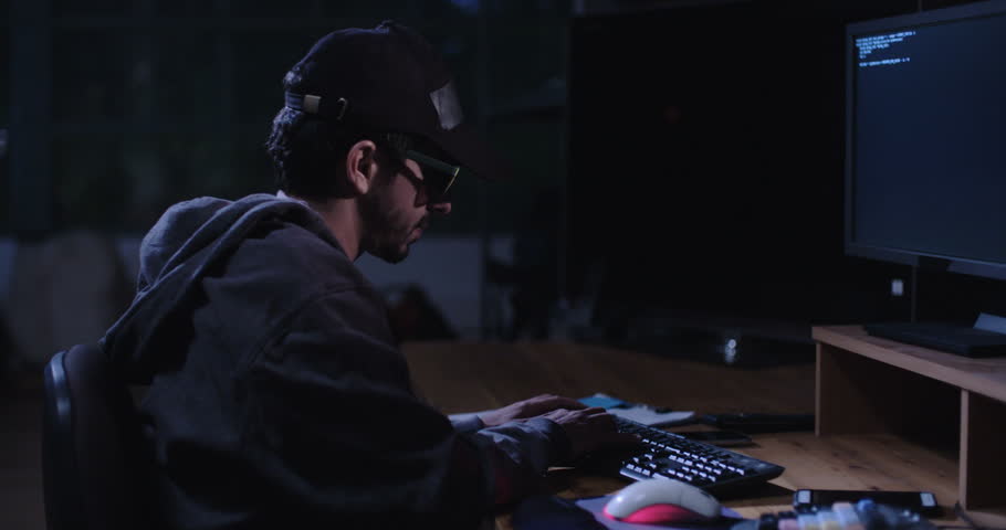Computer Hacker Sitting In A Dark Room In Front Of Computer Screens ...
