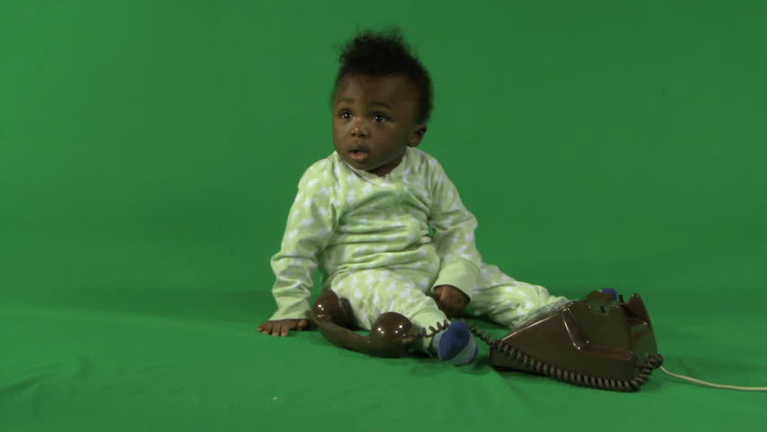 ZOOM IN LONG SHOT OF BABY PLAYING WITH BUILDING BLOCKS ON A GREEN ...