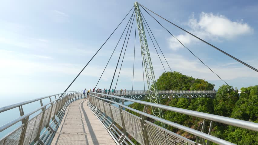 A Pedestrian Suspension Bridge Gently Sways In The Wind Amidst The ...
