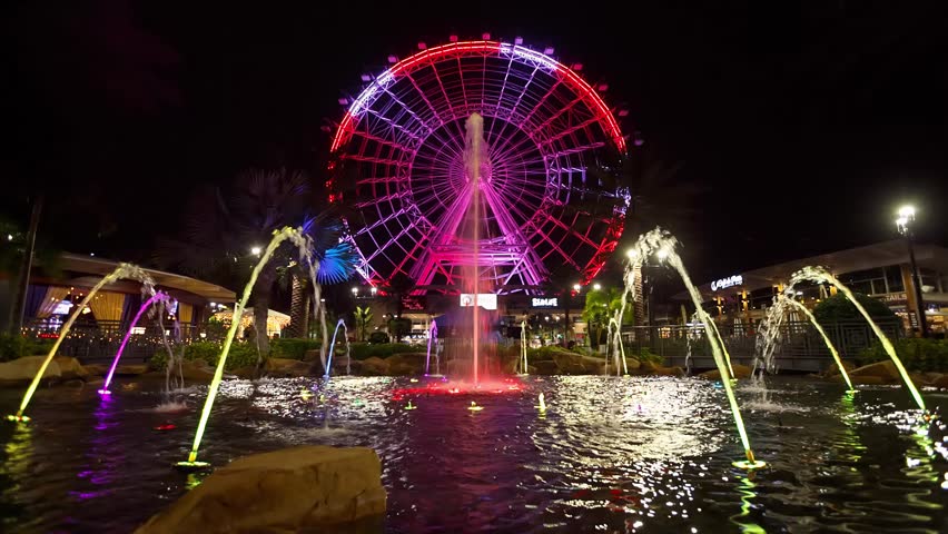 Time-lapse Of 'The Orlando Eye' With A Colored Fountain In Front. It Is ...