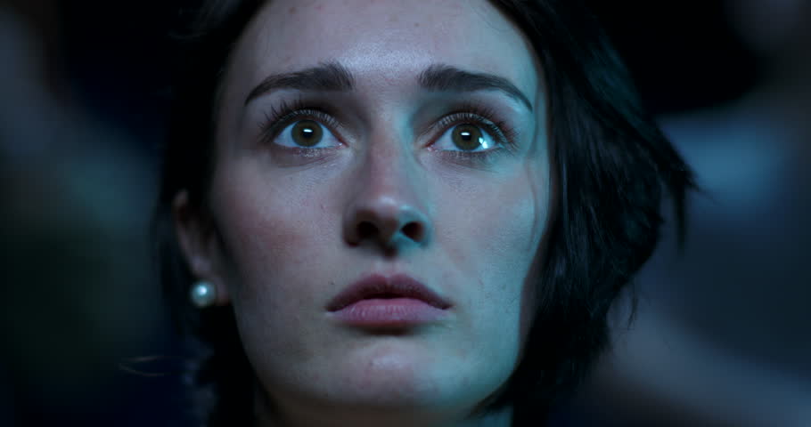 Close Up Of A Scared Young Woman Who Jumps With Fear While Watching A ...