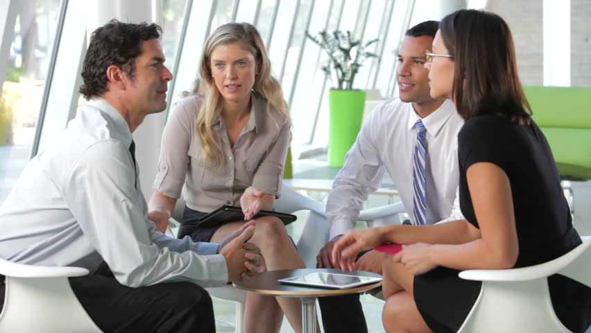 Three Businesswomen Sit And Have Informal Meeting Discussing Report ...