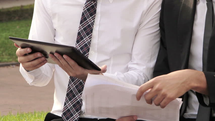 Stock Video Clip of Two business people with tablet computer talk ...