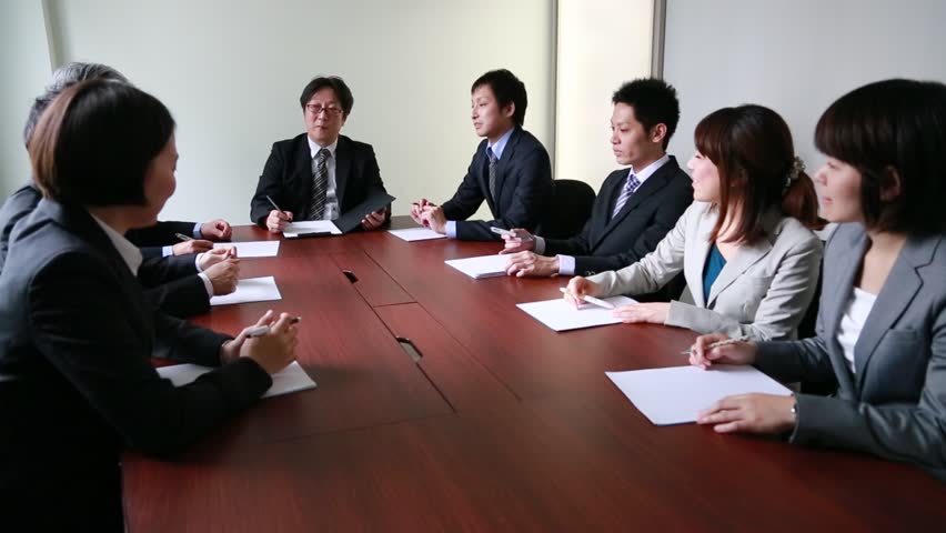 Japanese Business People Having A Meeting Around A Wooden Desk In A ...