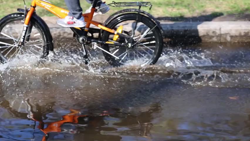 Riding Cyclist and Big Puddle Stock Footage Video (100% Royalty-free ...