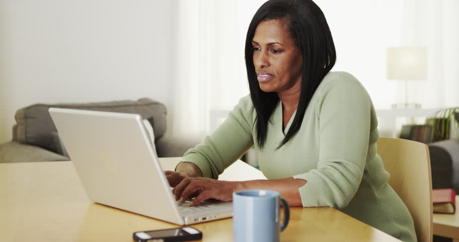 Black Senior Woman Shopping Online On Laptop Computer And Talking On ...