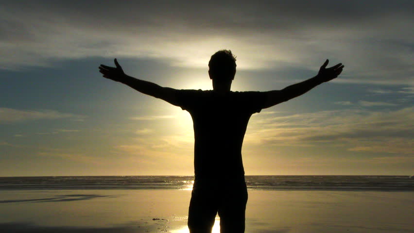 Silhouette Of Man Standing And Stretching Arms Up In Front Of Blue Sky ...